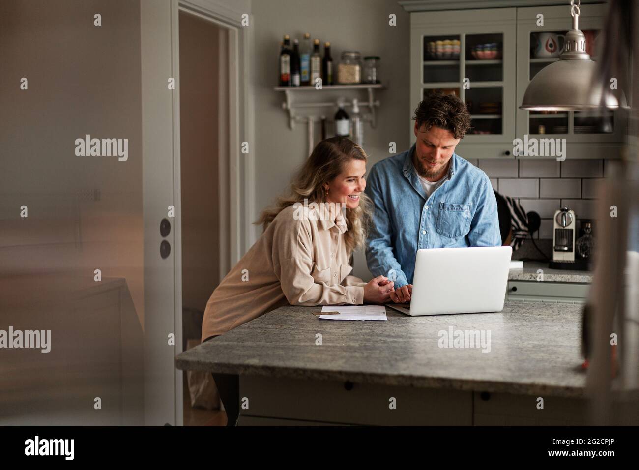 Couple using laptop at home Stock Photo - Alamy