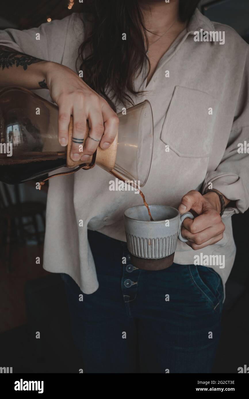 Woman pouring coffee into mug Stock Photo - Alamy