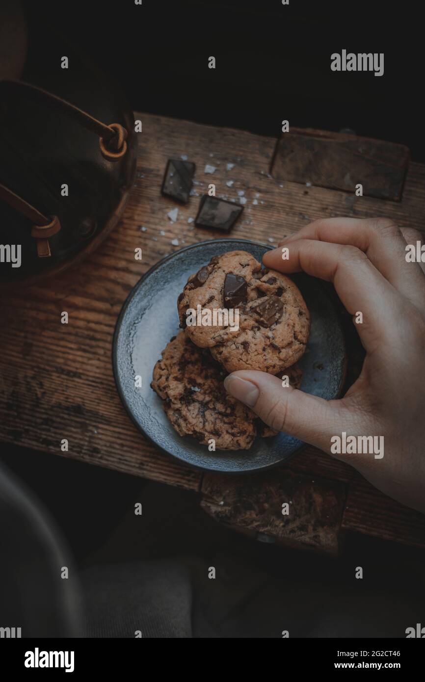 Hand holding chocolate chip cookie Stock Photo - Alamy