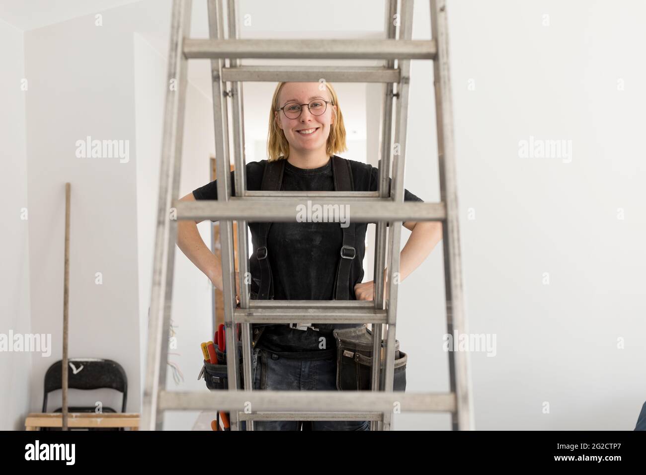 Woman standing behind ladder during house renovation Stock Photo - Alamy