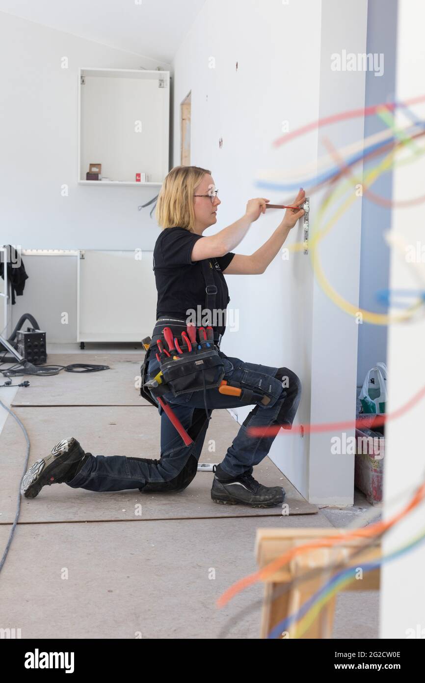 Female electrician renovating house Stock Photo - Alamy
