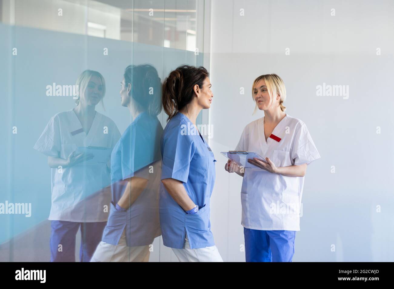 Female nurse and doctor talking in hospital Stock Photo - Alamy