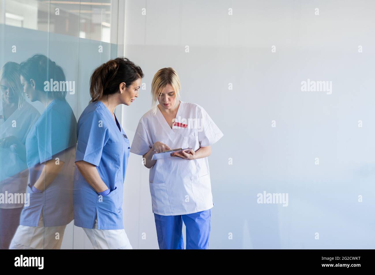 Female nurse and doctor checking file Stock Photo - Alamy