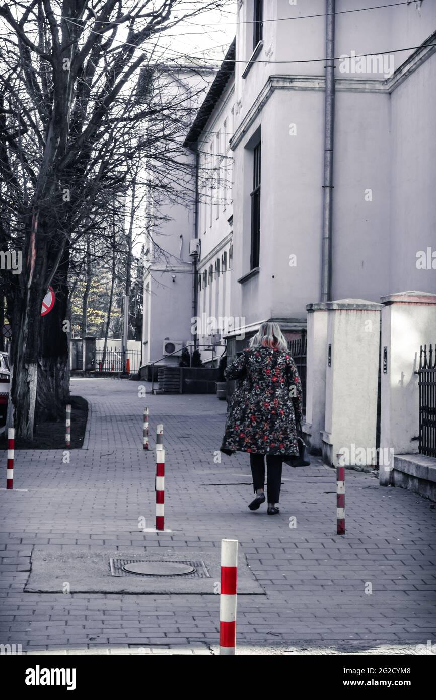 Back view of a female pedestrian walking down the city street Stock ...
