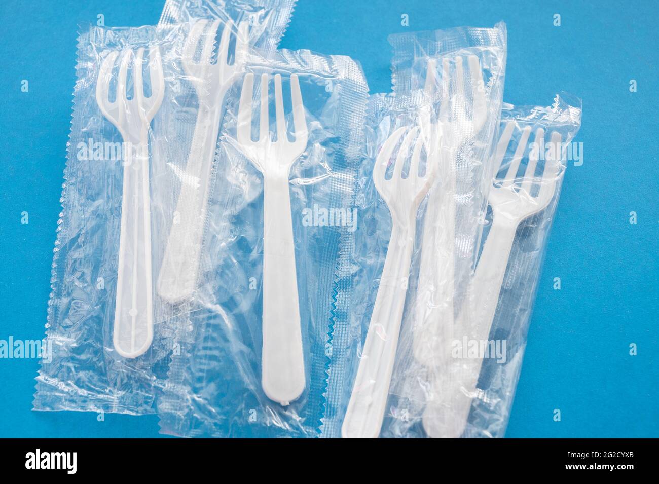 Disposable plastic forks on a blue background Stock Photo - Alamy