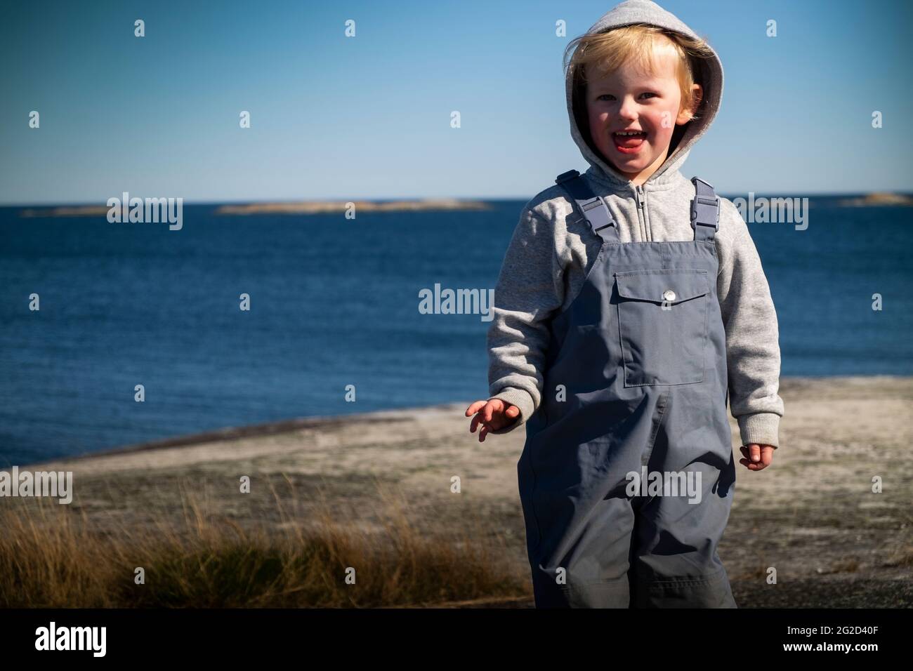 Happy boy standing at sea Stock Photo - Alamy