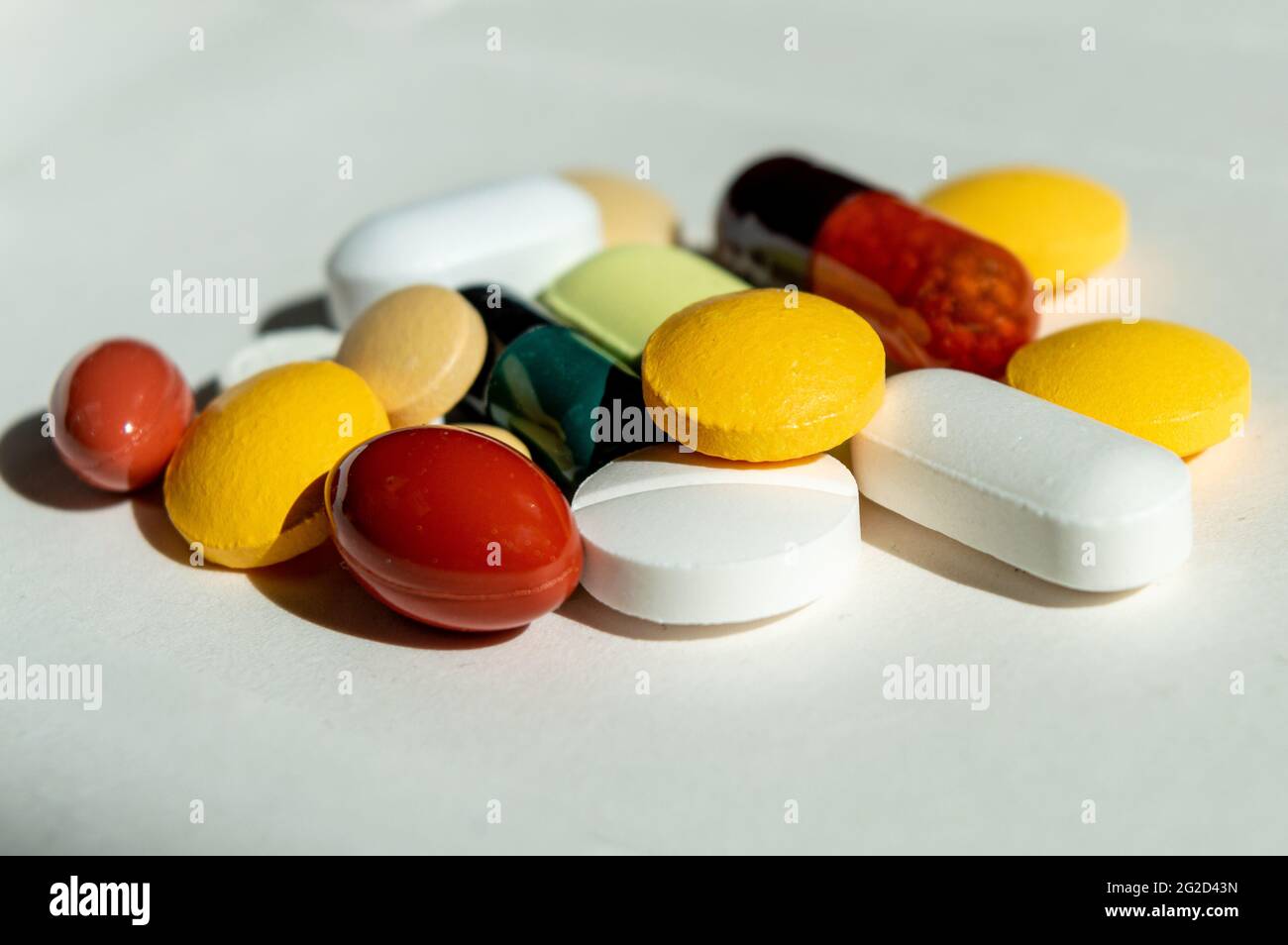 Pills of different colors and shapes on a white background.different ...