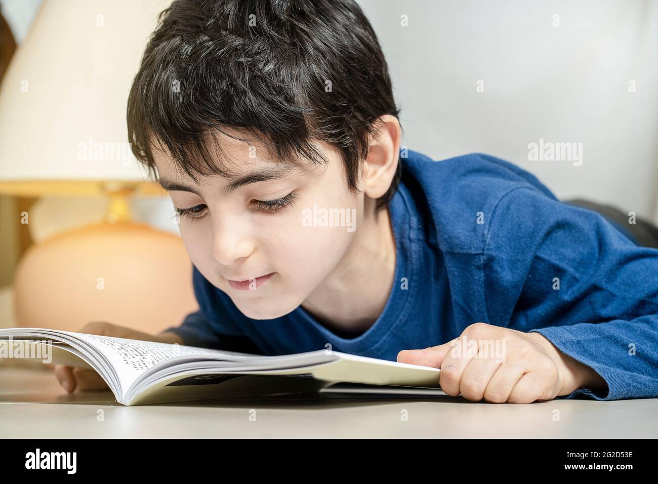 little boy reading book under a tent at home alone Stock Photo - Alamy