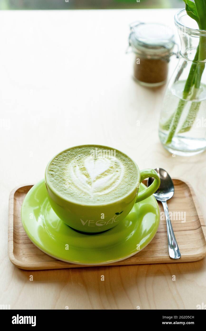 Matcha latte with a heart in a green cup in a café Stock Photo - Alamy