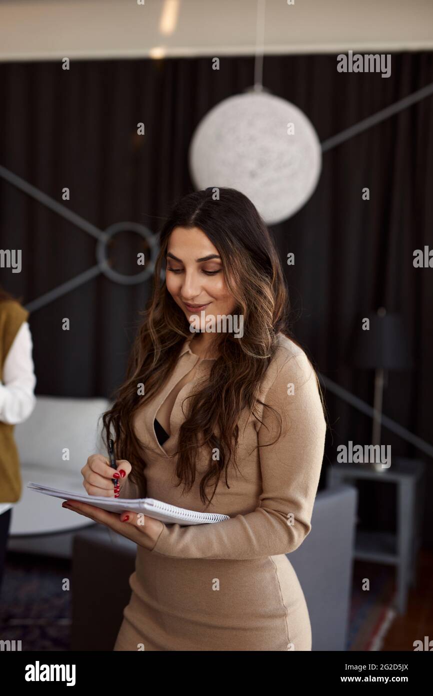 Businesswoman at work taking notes Stock Photo - Alamy