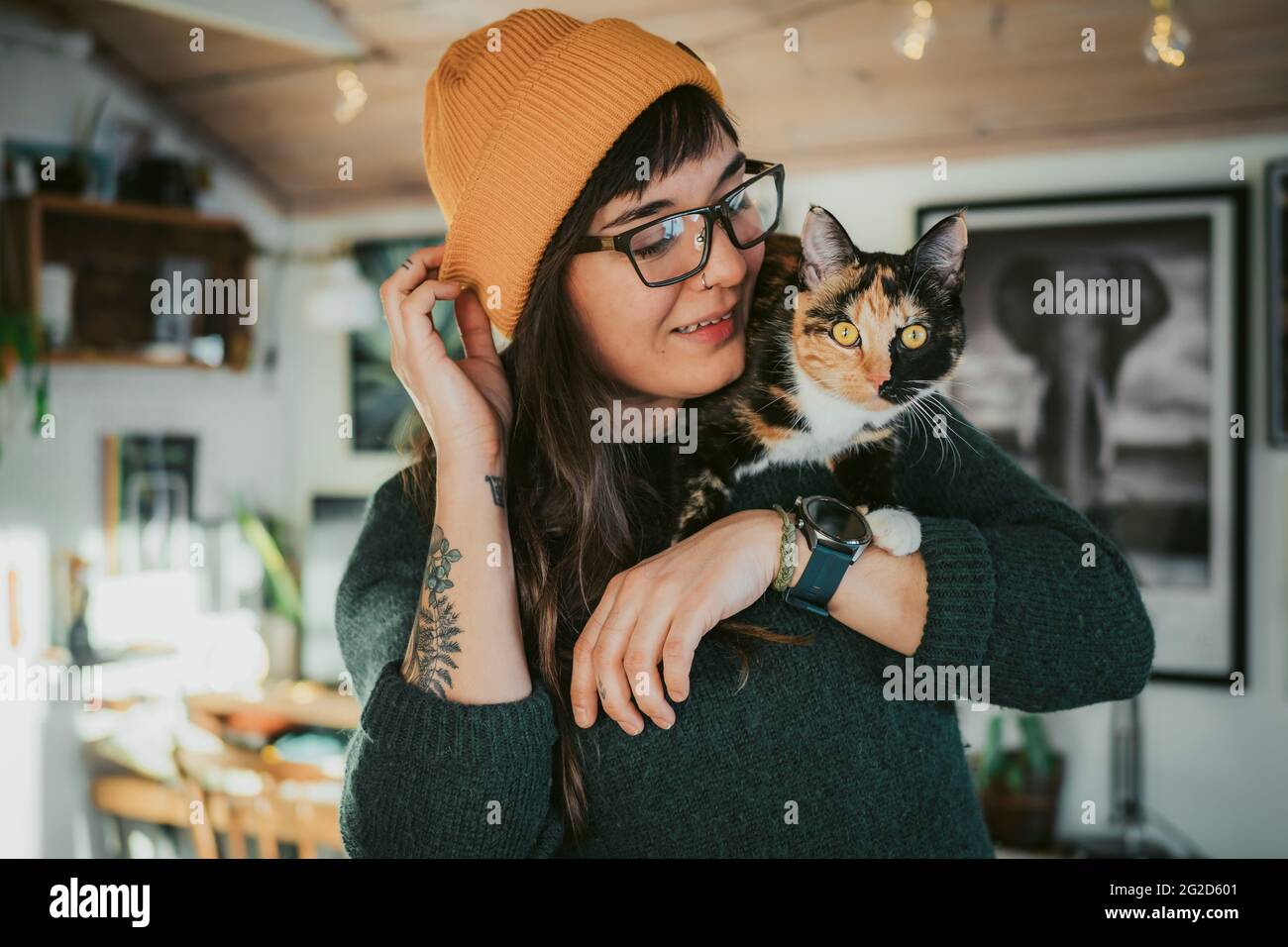 Young woman carrying cat on shoulder Stock Photo - Alamy