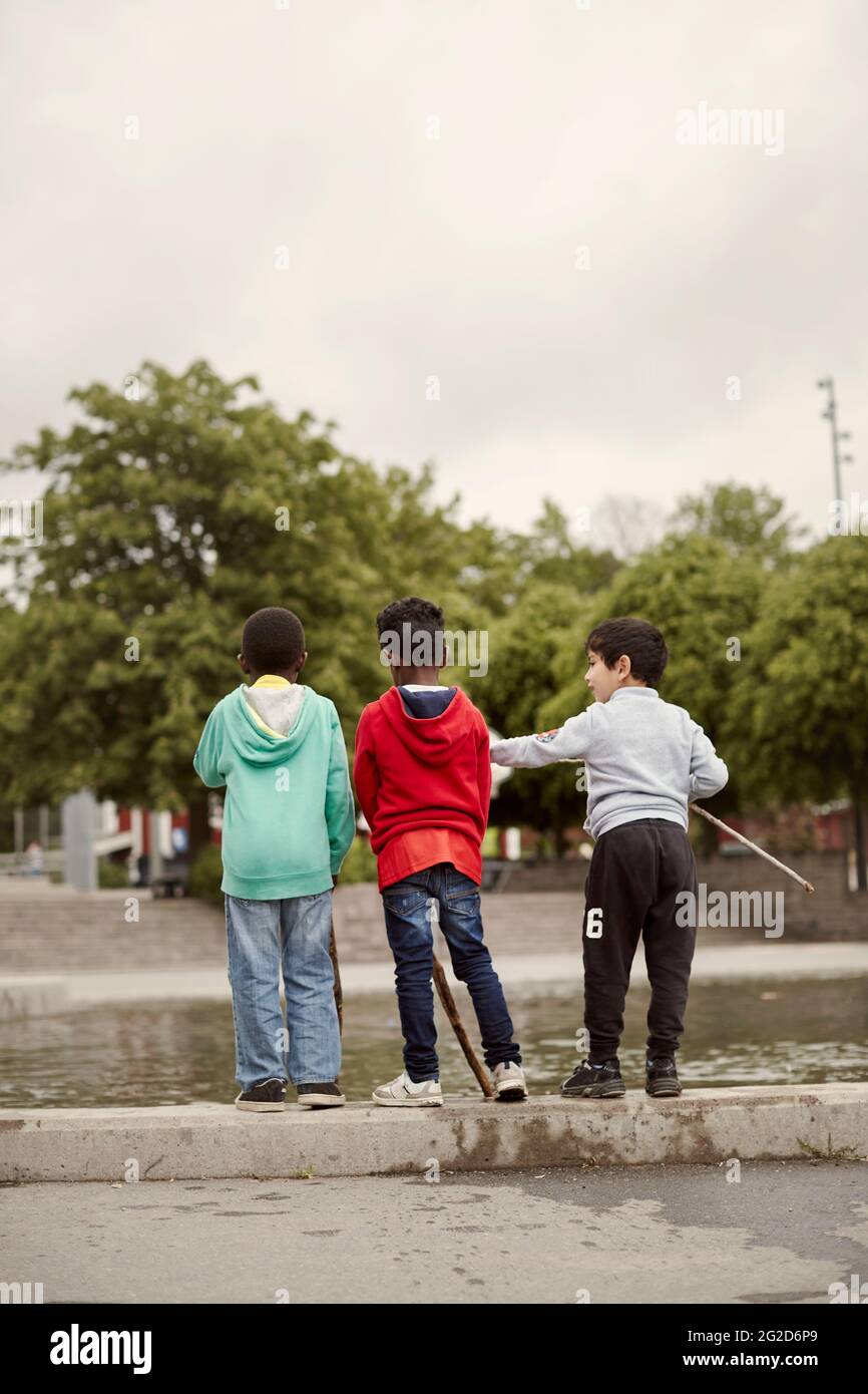 Rear view of boys standing together Stock Photo - Alamy
