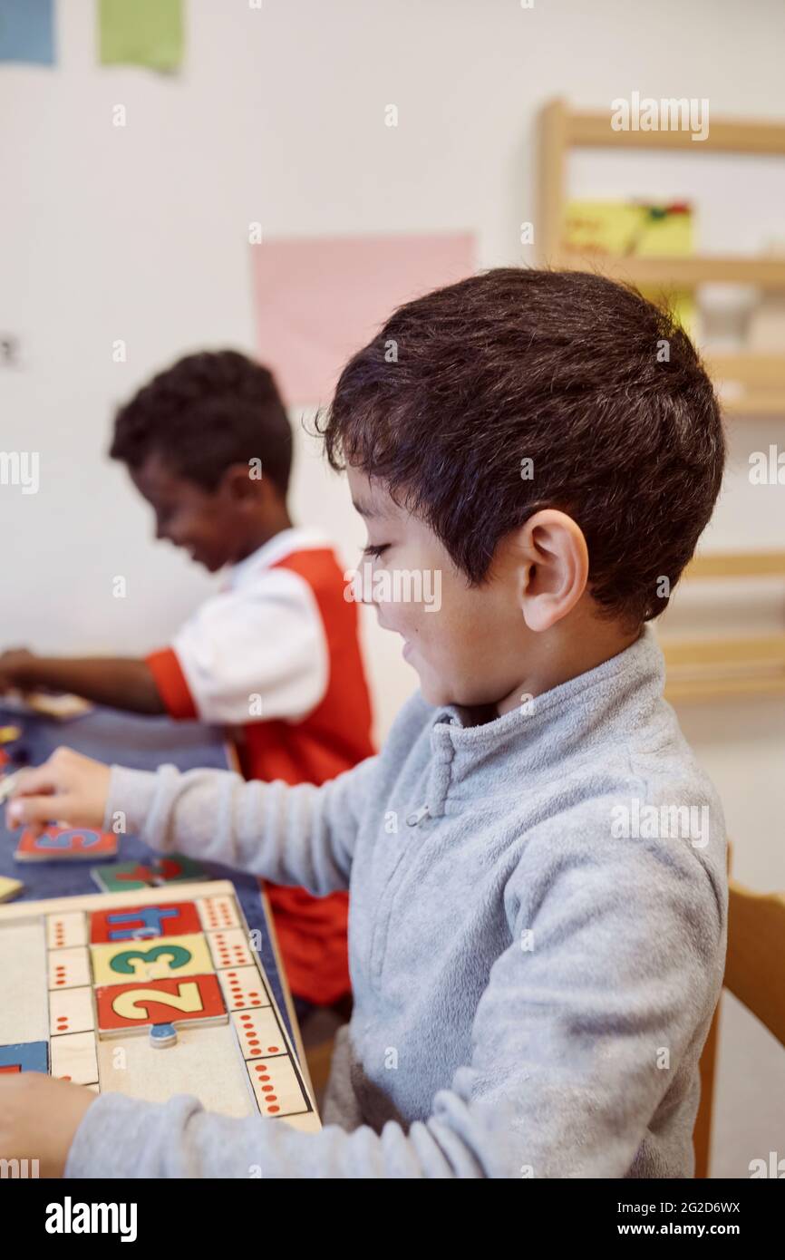 Boy doing puzzle in classroom Stock Photo - Alamy