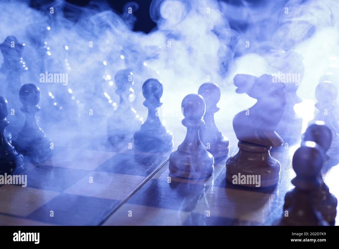 Chess is a board game. Chess pieces on a dark background in smoke Stock ...