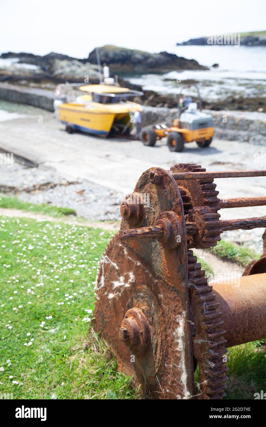 A small ferry / yellow boat being launched by dump truck at Ynys Enlli ...