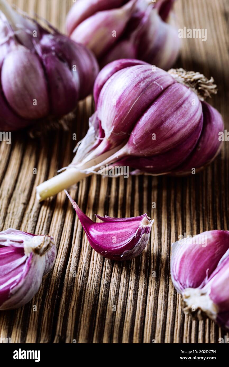 Raw purple garlic on wood board. Rustic style, close up, selective ...
