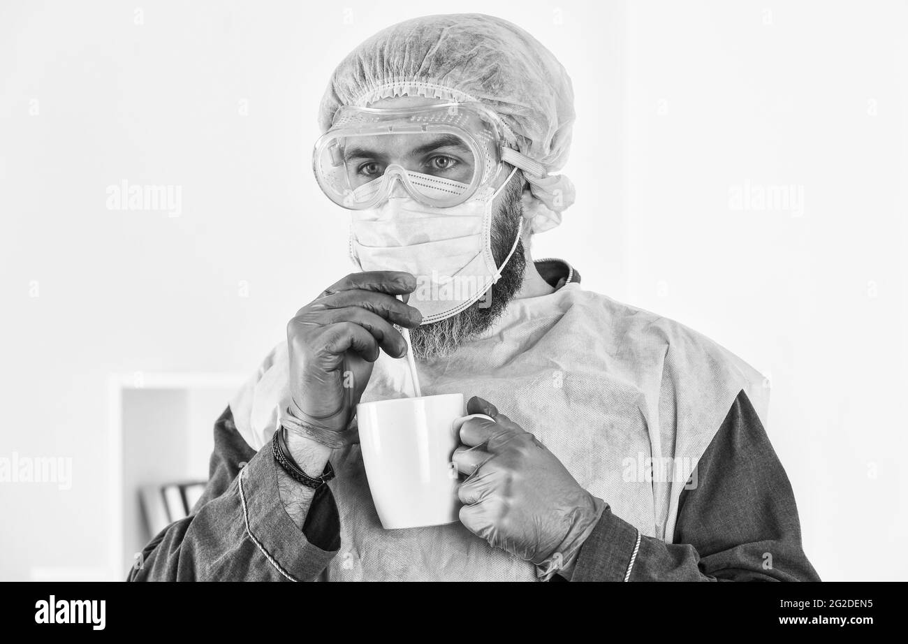 man drink coffee in respirator protective mask. coronavirus pandemic ...