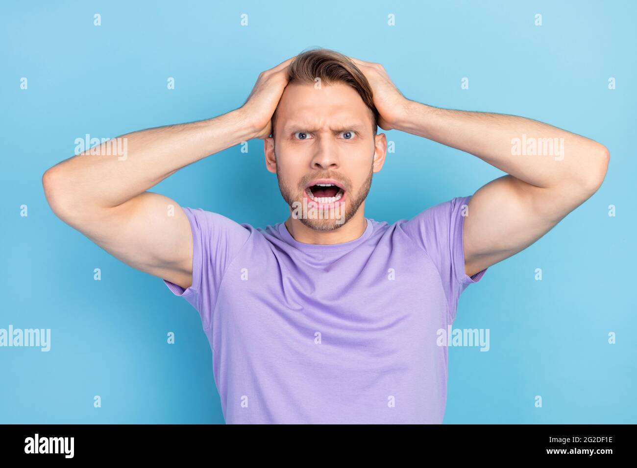 Photo portrait of guy keeping hands on head staring amazed got trouble ...