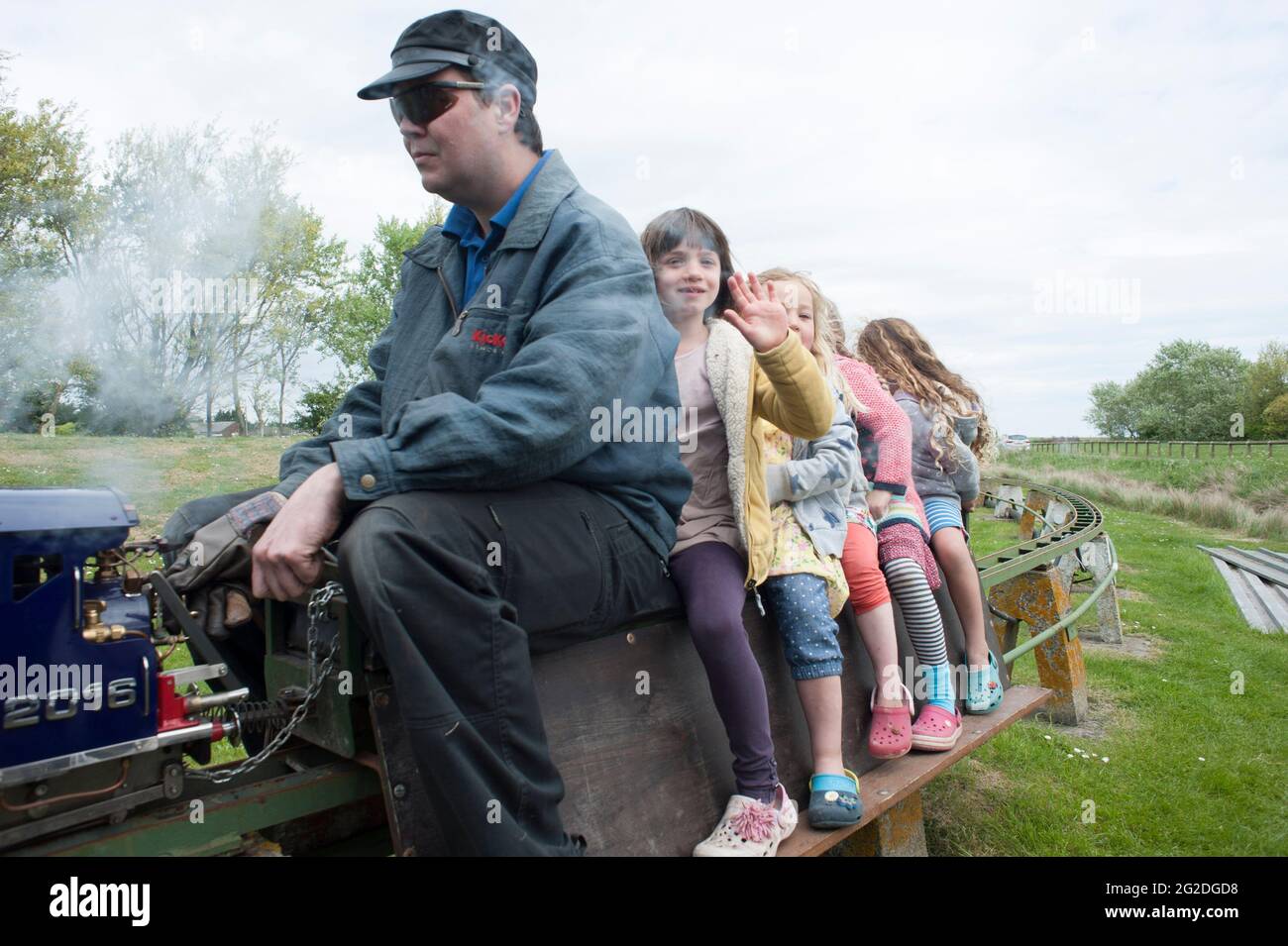 A train driver takes kids on a fun amusement miniature railway train on ...