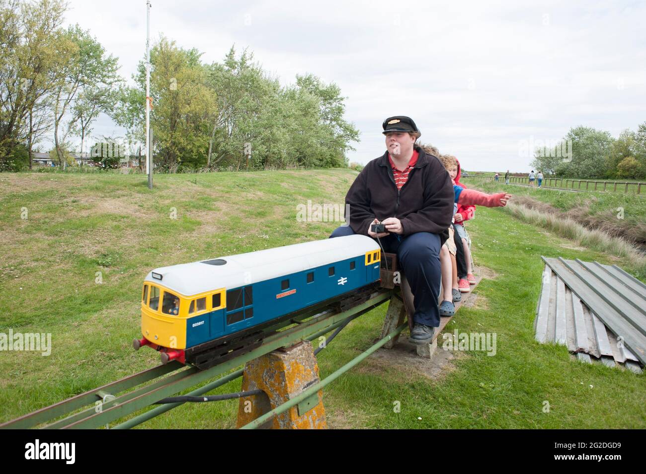 A train driver takes kids on a fun amusement miniature railway train on ...