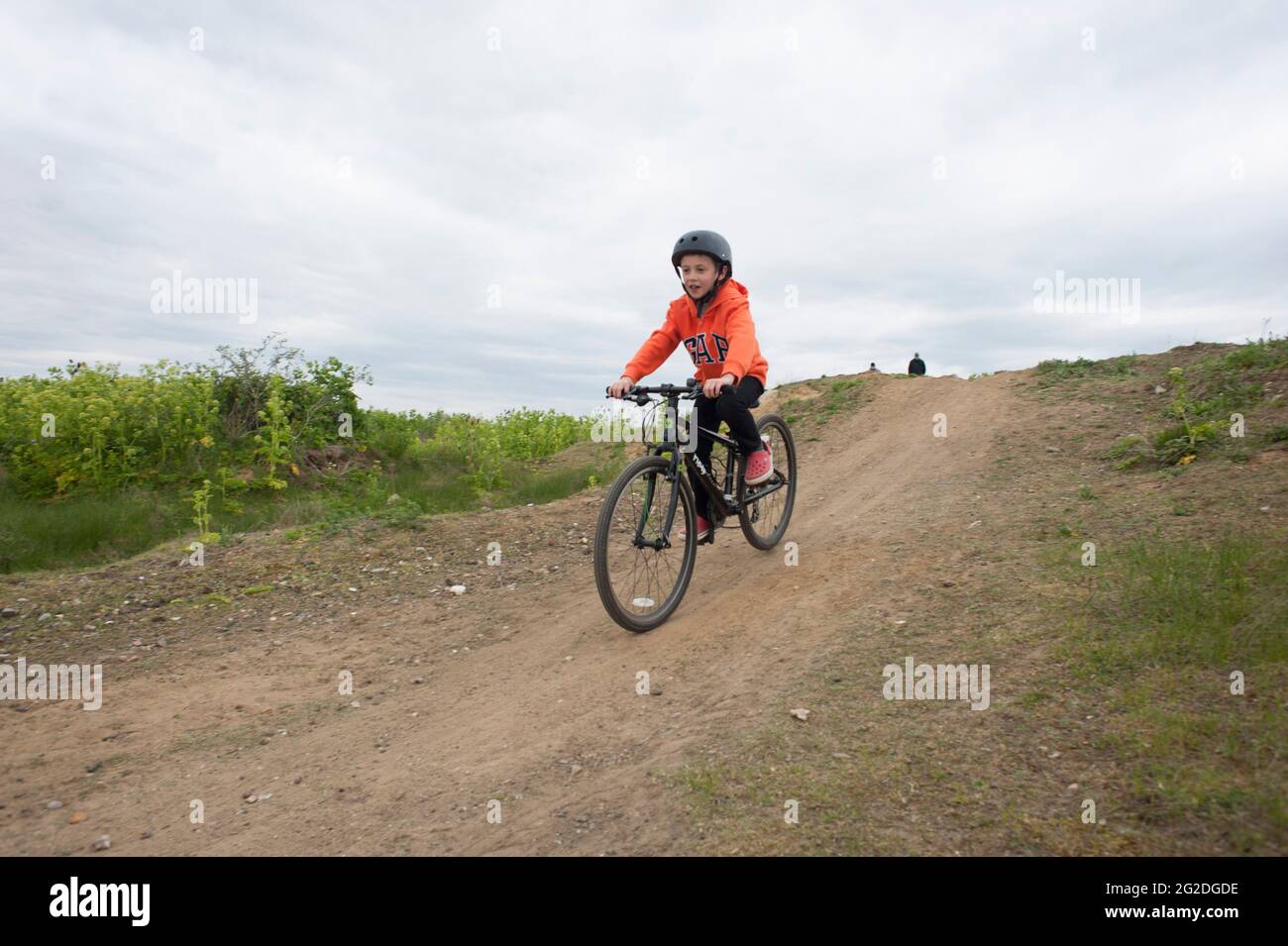 A kid on a childs bike on a cycle path wearing a helmet Stock Photo - Alamy
