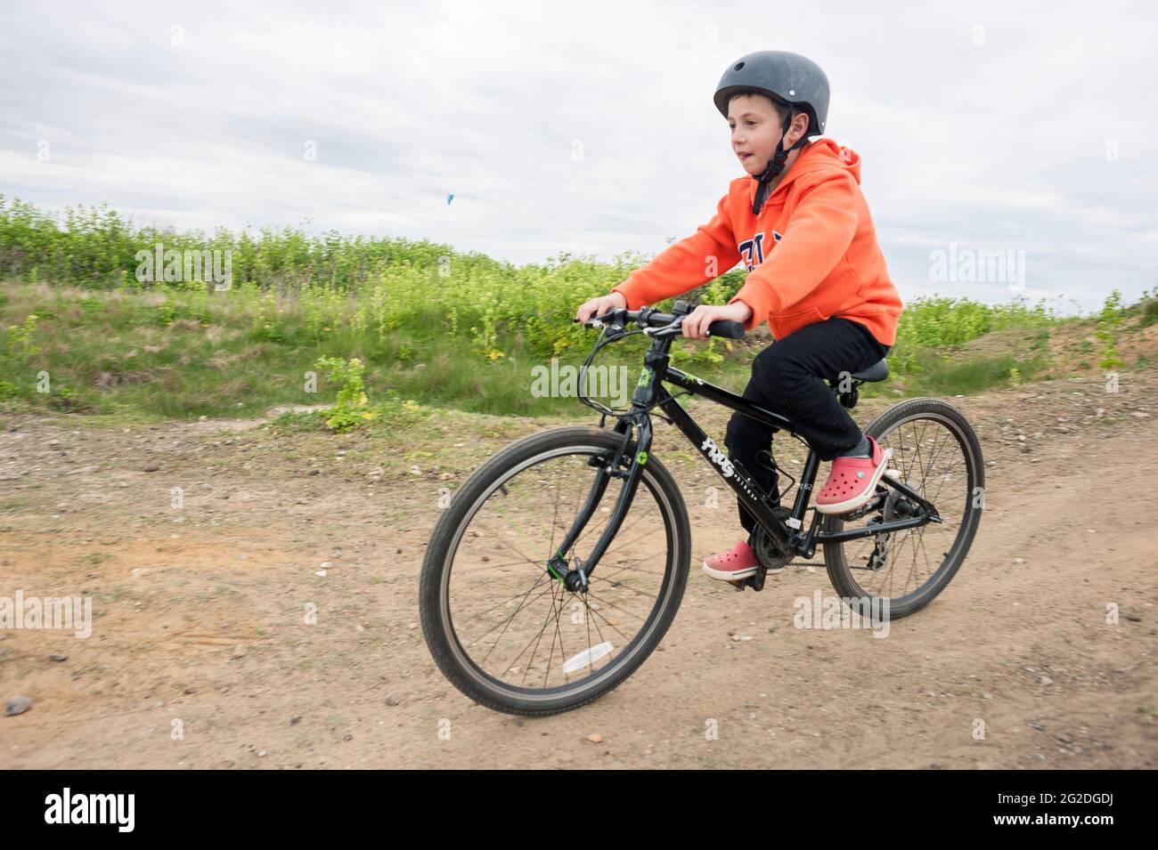 A kid on a childs bike on a cycle path wearing a helmet Stock Photo - Alamy