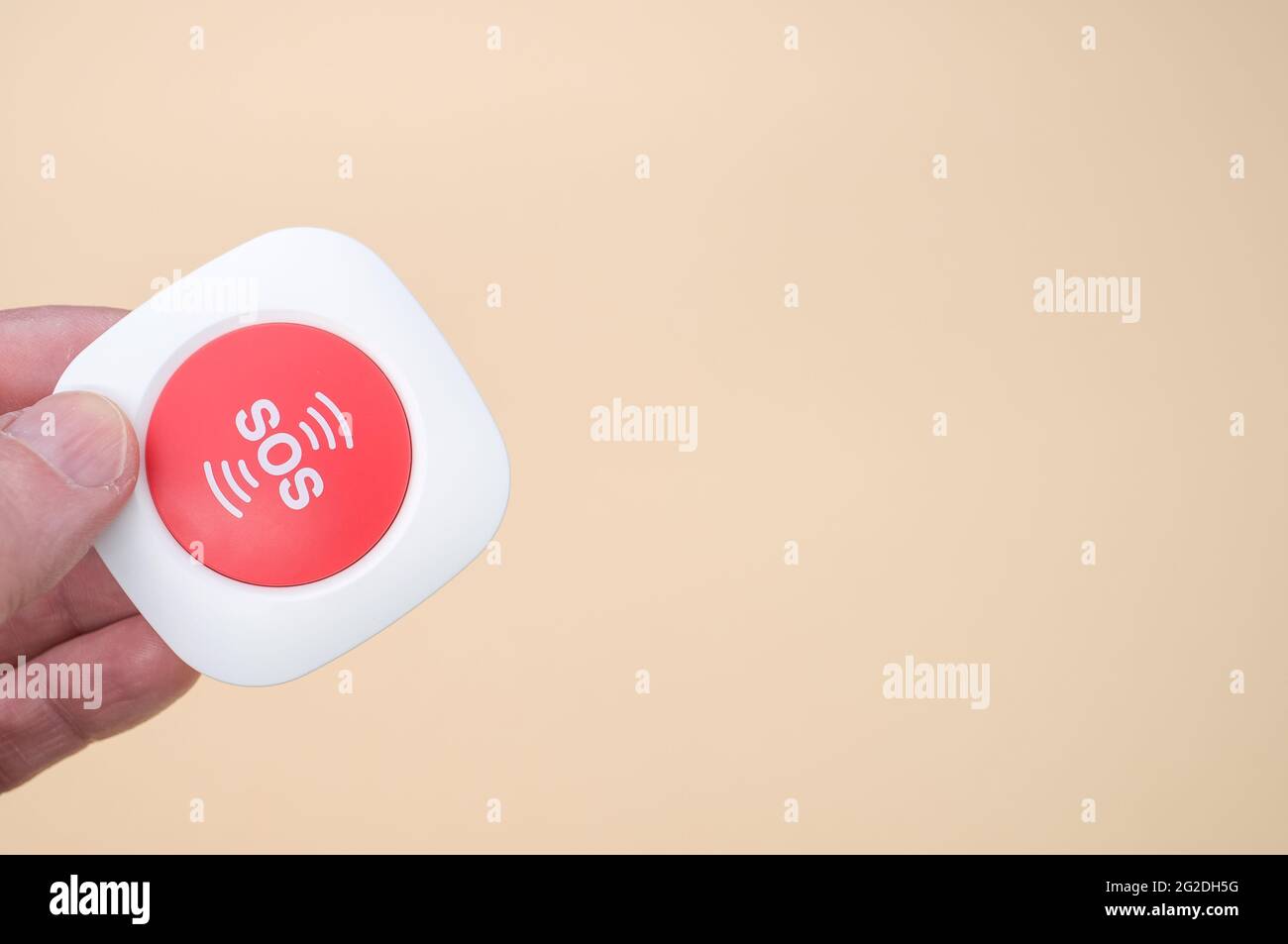 Elderly hand holding a wireless SOS emergency alarm button isolated on ...