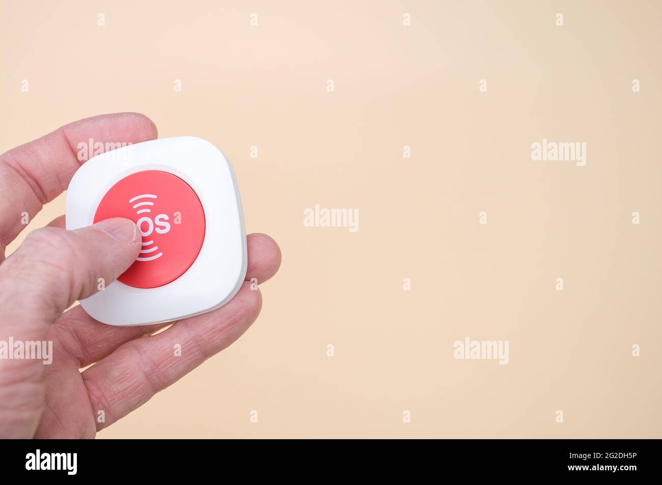 Elderly hand holding a wireless SOS emergency alarm button isolated on ...