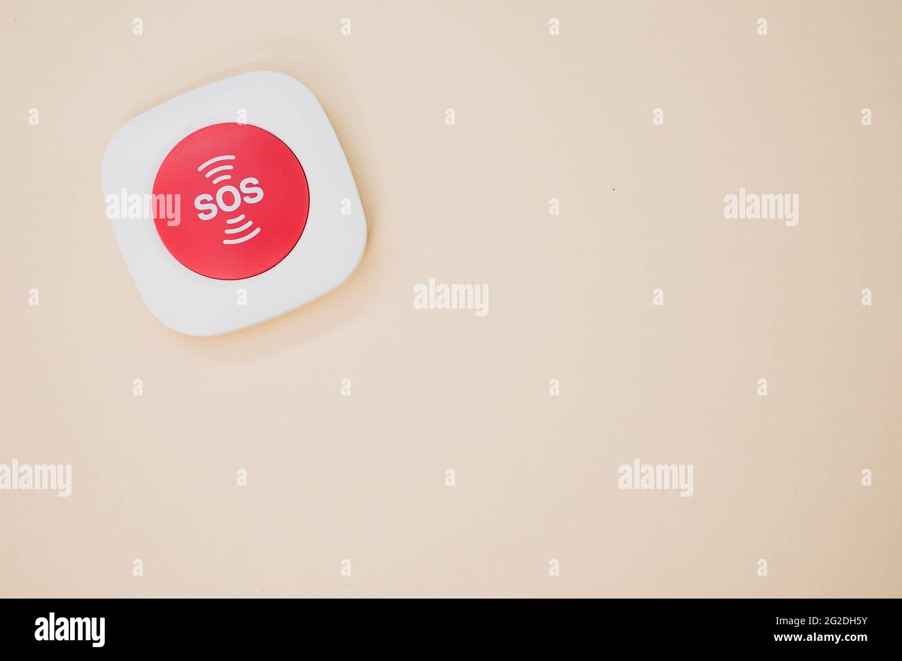 Top view of wireless SOS emergency alarm button isolated on light brown ...