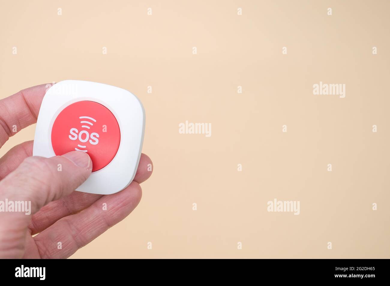 Elderly hand holding a wireless SOS emergency alarm button isolated on ...