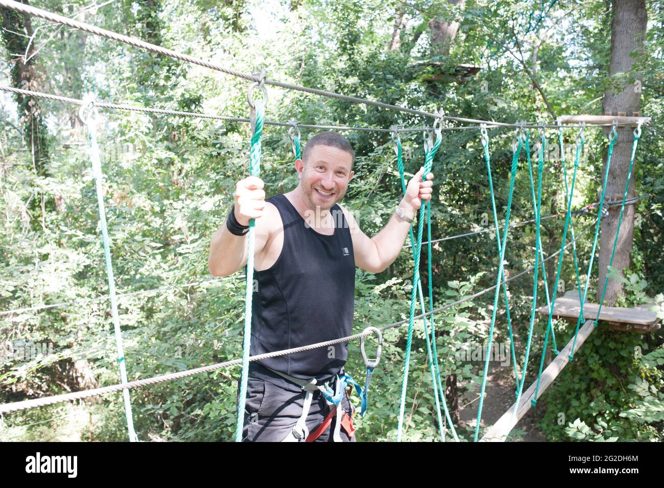 A person enjoying the fun of a nature park with rope swings, ladders ...