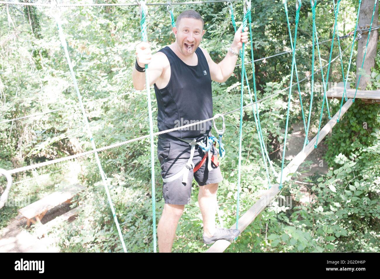 A person enjoying the fun of a nature park with rope swings, ladders ...