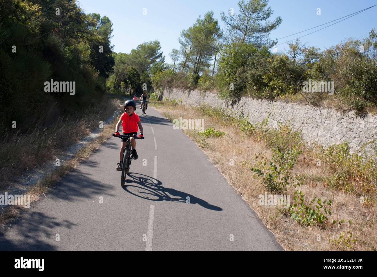 A kid on a childs bike on a cycle path wearing a helmet Stock Photo - Alamy