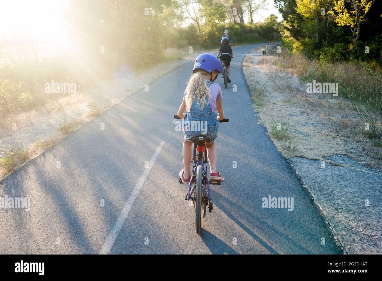 A kid on a childs bike on a cycle path wearing a helmet Stock Photo - Alamy