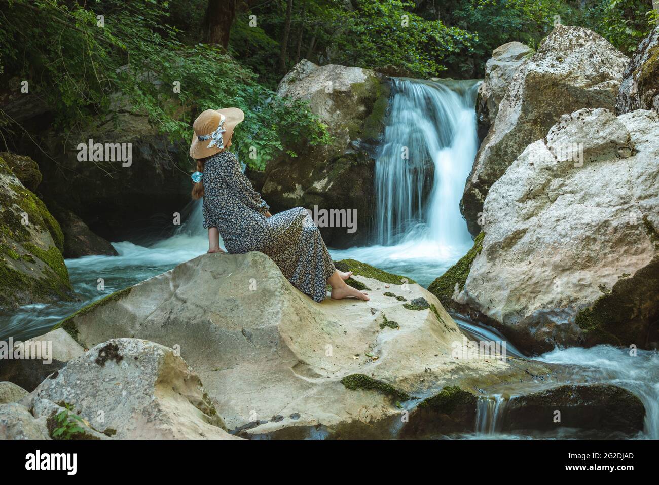 young woman with hat enjoying in nature, relaxing and thinking in ...