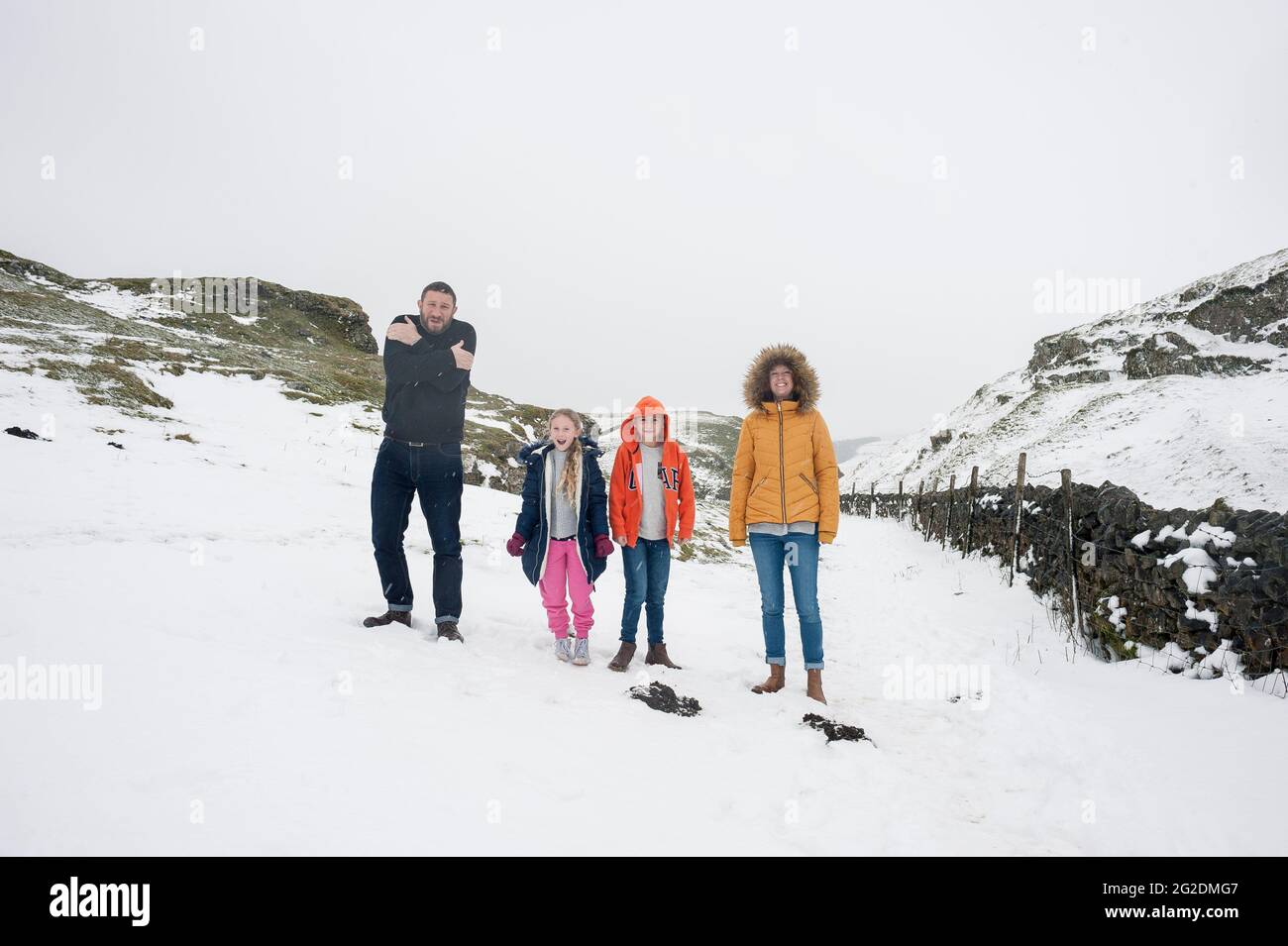 A family have fun in the cold snow which has settled on the ground ...