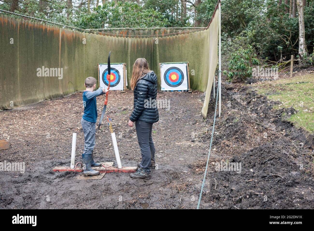 A young child has a go at archery in front of a target Stock Photo - Alamy
