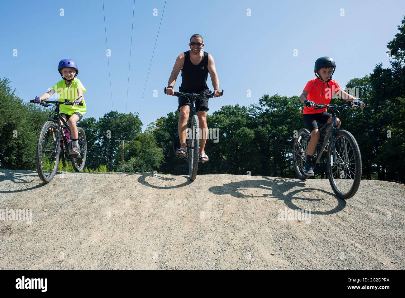 A family riding bikes in France in the summer on cycle paths exploring ...