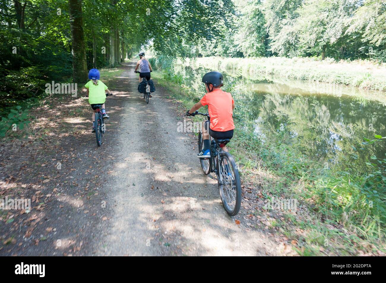 A family riding bikes in France in the summer on cycle paths exploring ...