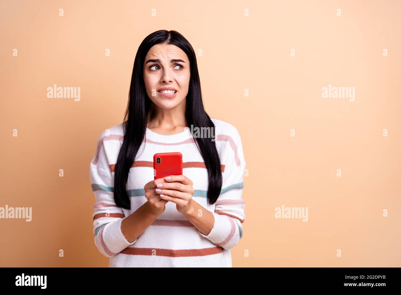 Photo of young nervous girl worried bite lips teeth fail use smartphone ...