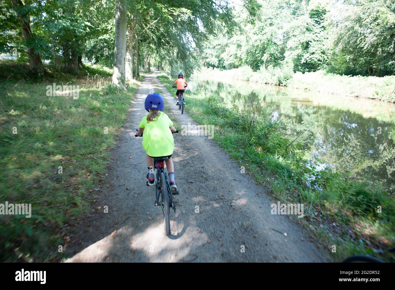 A family riding bikes in France in the summer on cycle paths exploring ...