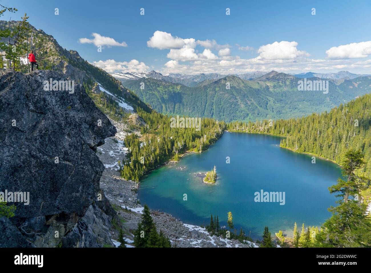 Person Standing over a Cliff overlooking a beautiful landscape in the ...