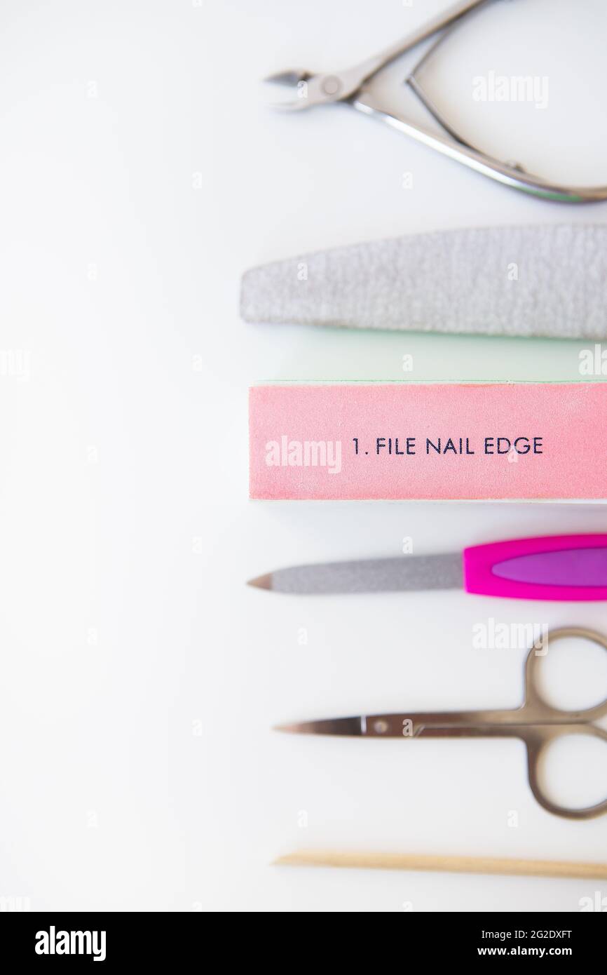 Manicure tools set on a white background. File, buff, scissors, orange ...