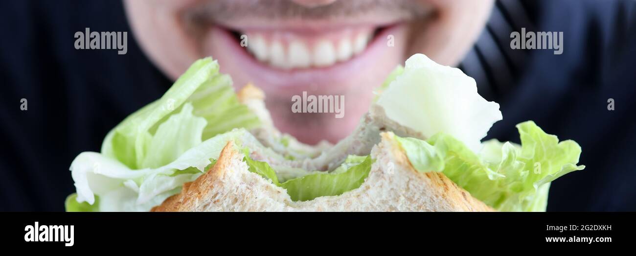 Man holding sandwich in hands and smiling closeup Stock Photo - Alamy