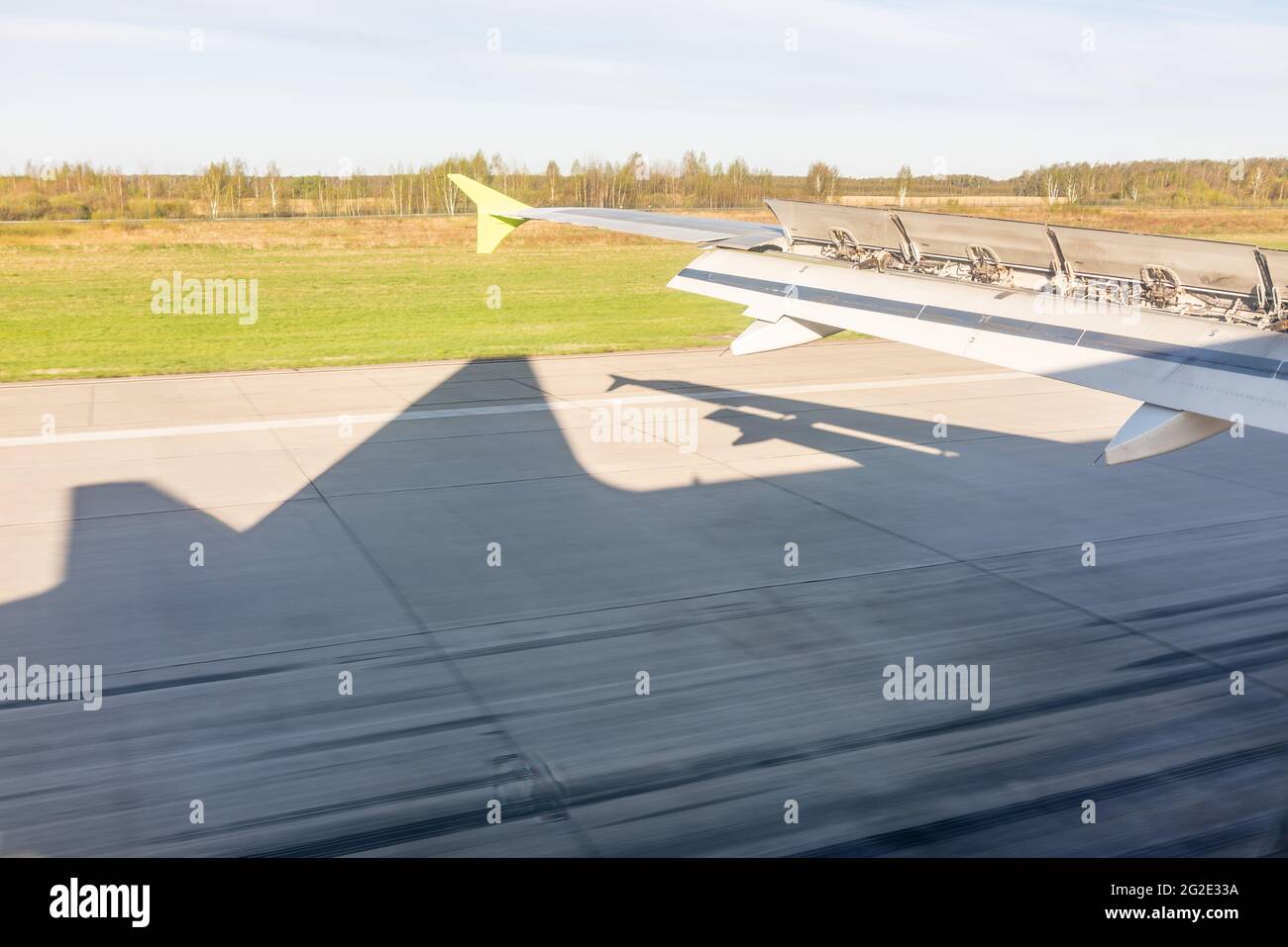 View of airplane wing, Shadow of the plane on the ground during landing ...