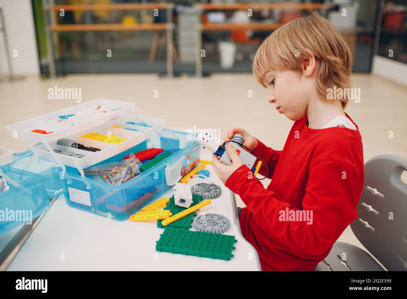 Little boy with robotic constructor assembling technical toy. Children ...