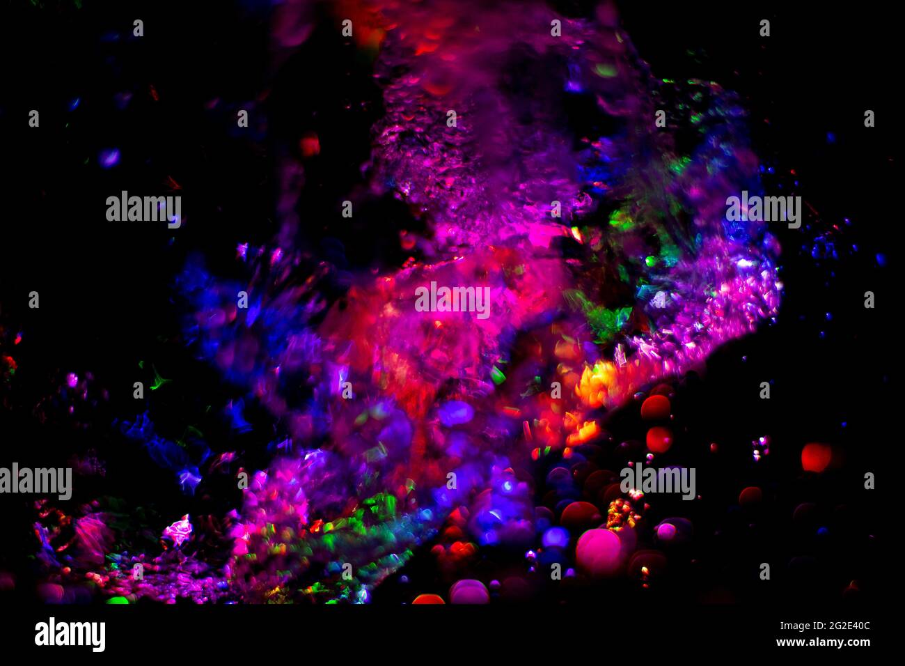 Colored water texture. Splashes of water lit in different colors. Close ...