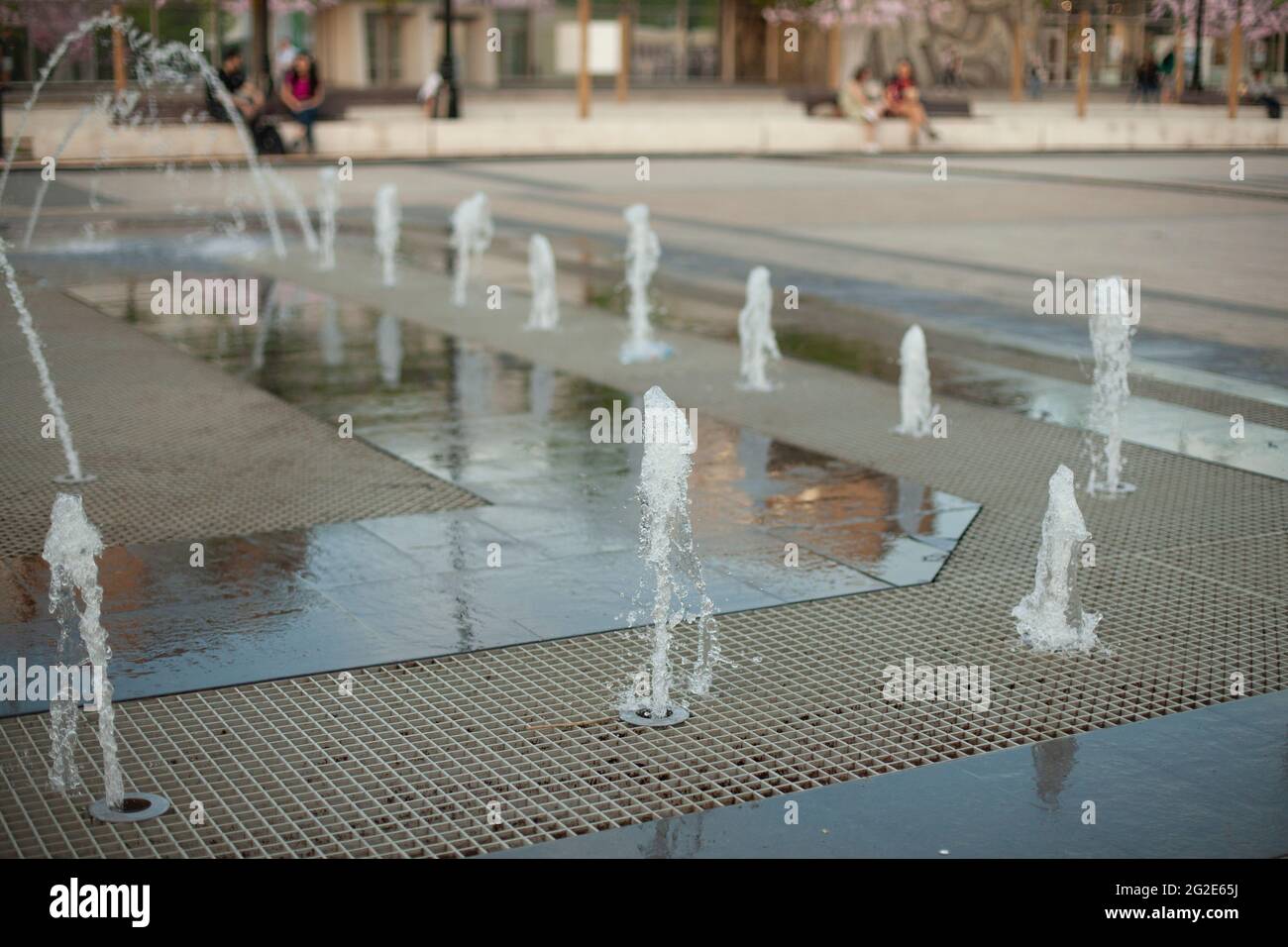 City fountain in the square. Water gushes out from sidewalks. Plane ...
