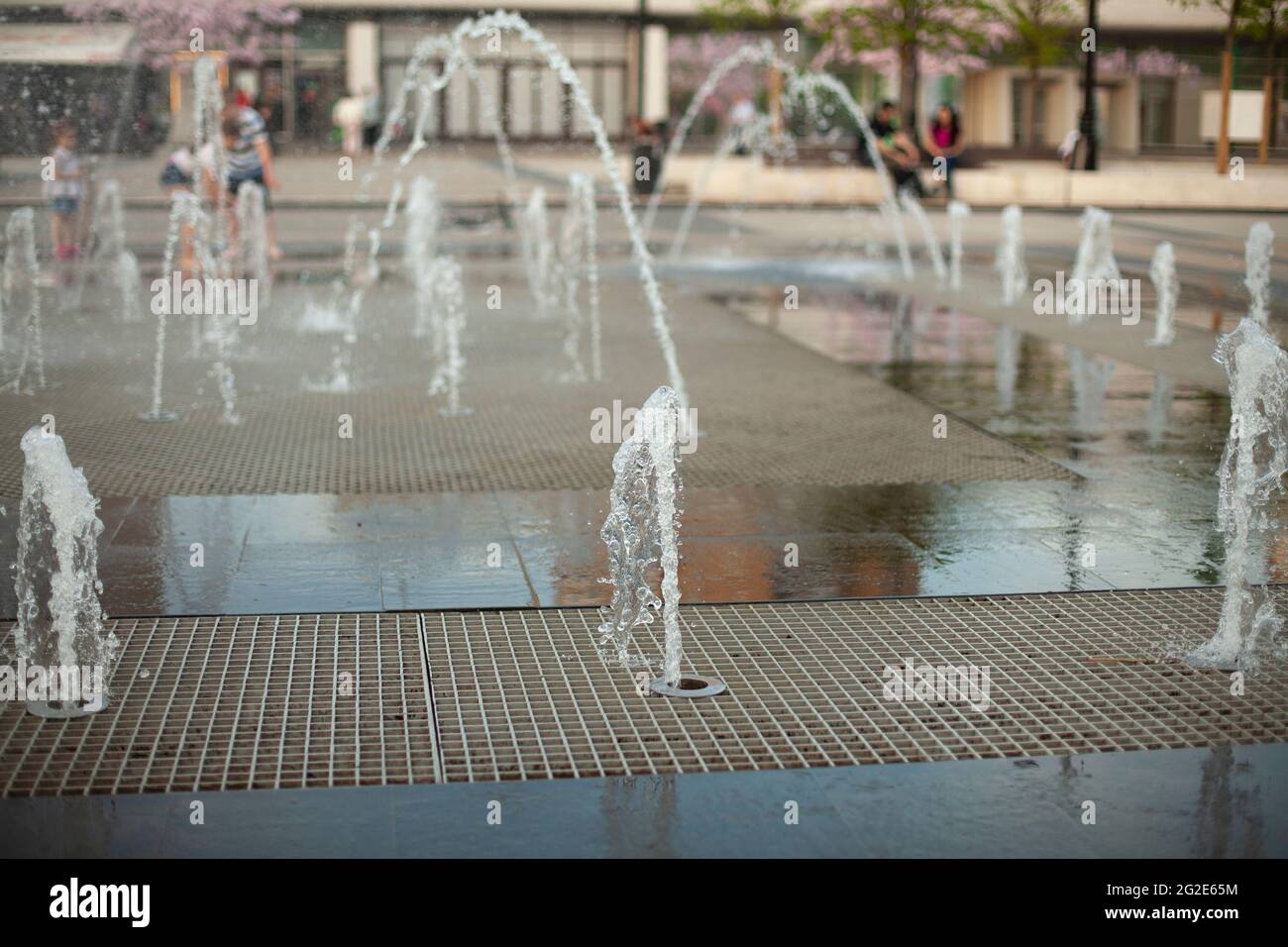 City fountain in the square. Water gushes out from sidewalks. Plane ...