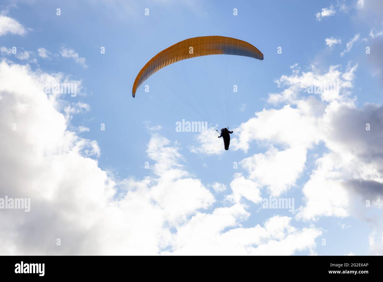 Adventurous Man Flying on a Paraglider around the mountains Stock Photo ...